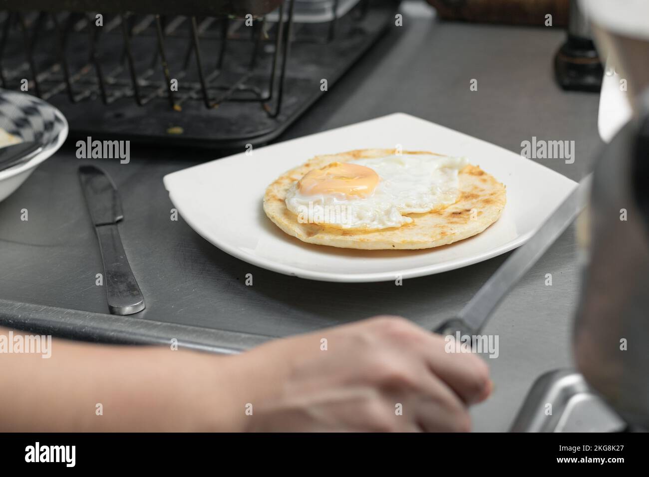 typical colombian breakfast served on a white plate on top of a metal ...