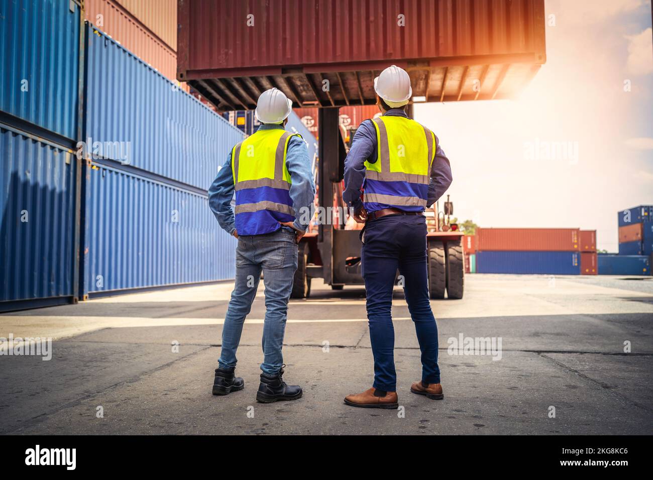 Two Engineer or foreman wears PPE checking container storage with cargo ...