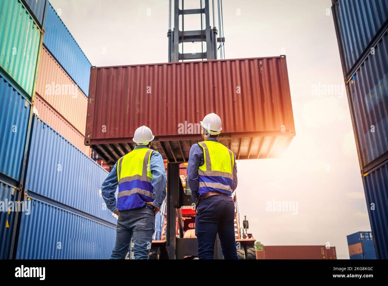 Two Engineer or foreman wears PPE checking container storage with cargo ...
