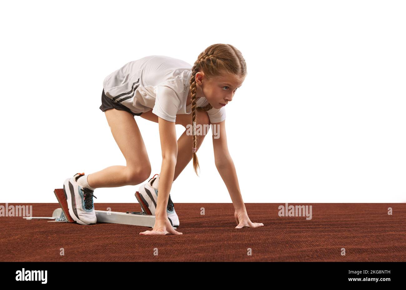 School age girl, junior runner or jogger at starting position ready to ...