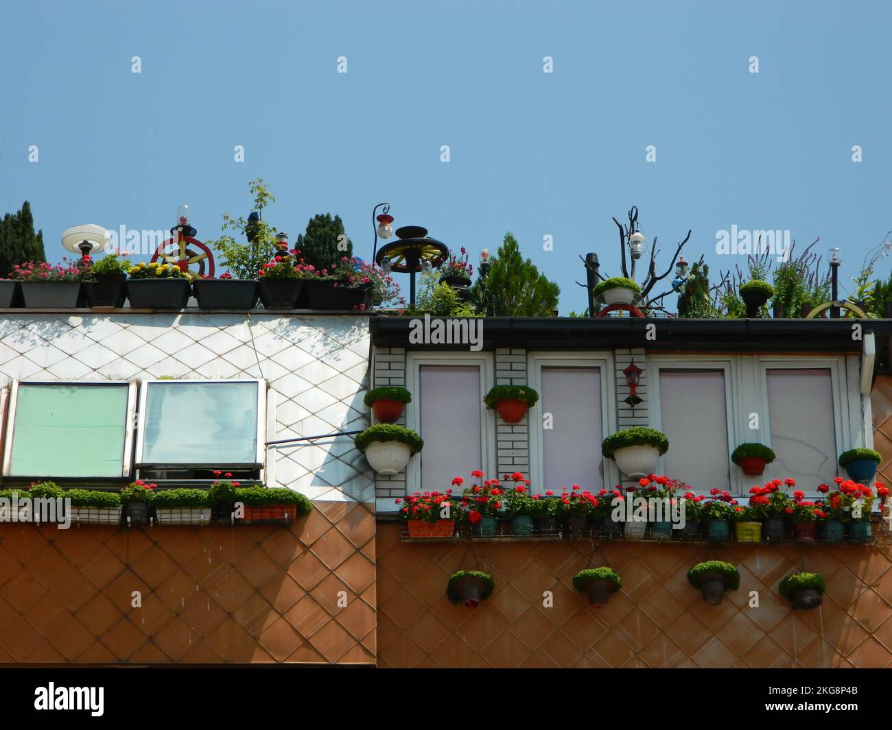 The low-angle view of a cozy decorated buildings facade under the blue ...