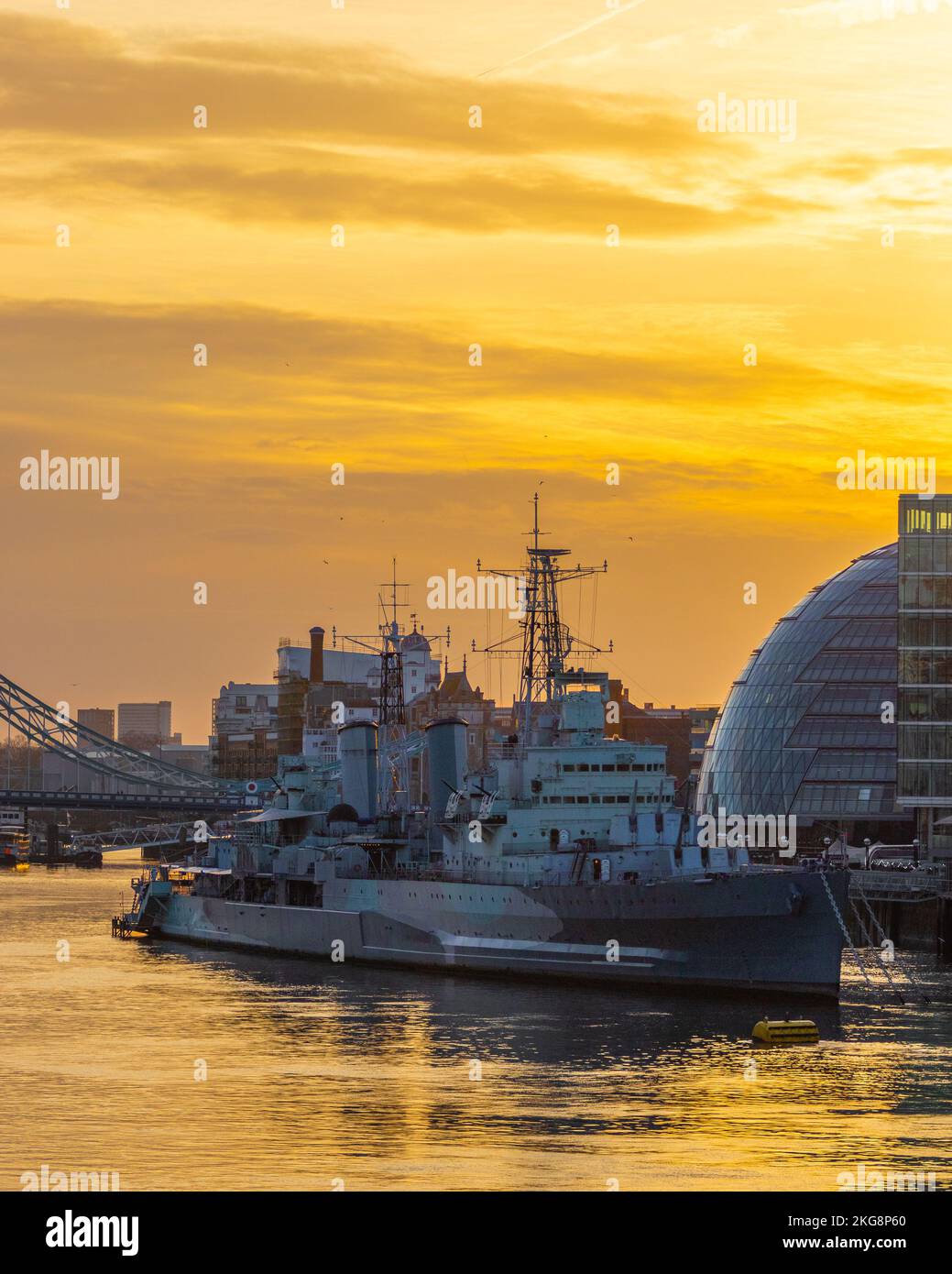A golden sunrise over the River Thames with tower bridge and HMS Belfast, Long exposure Stock ...