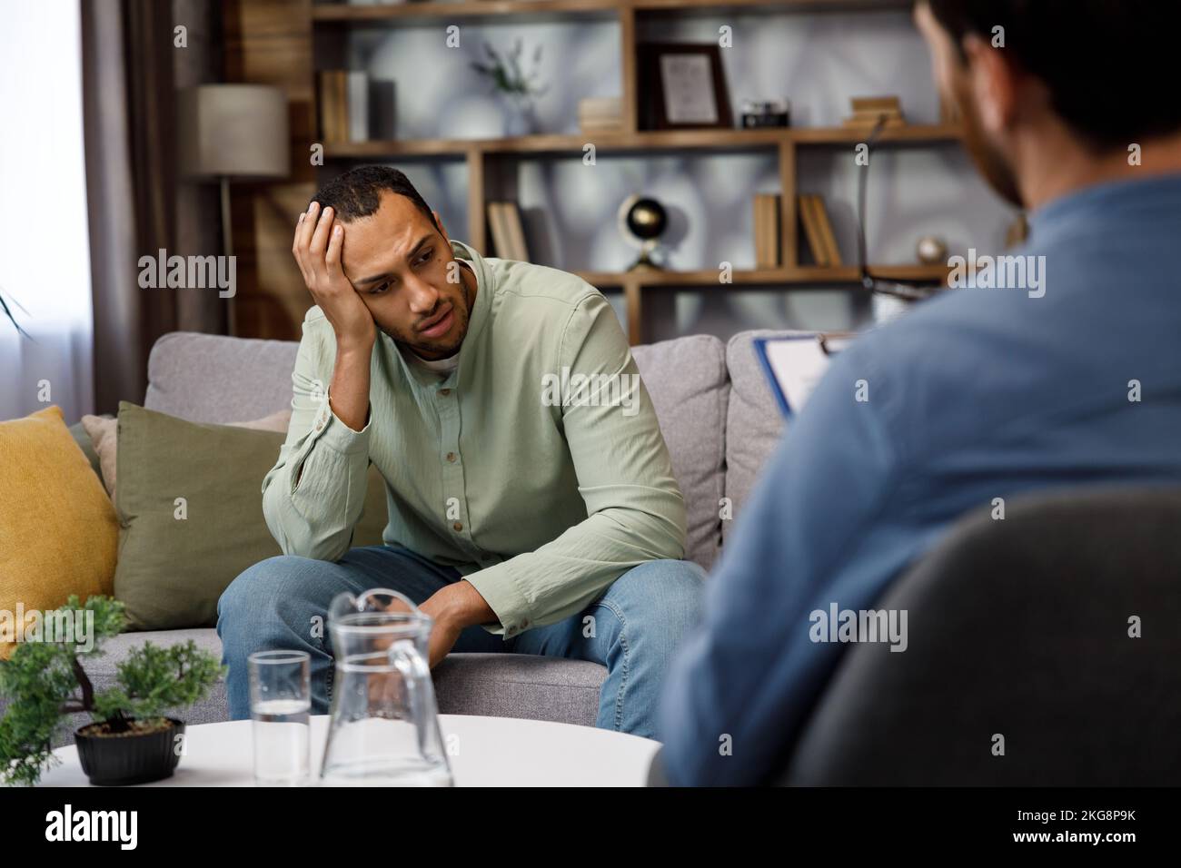 A visit to an African American psychologist. A man sits on a couch and ...