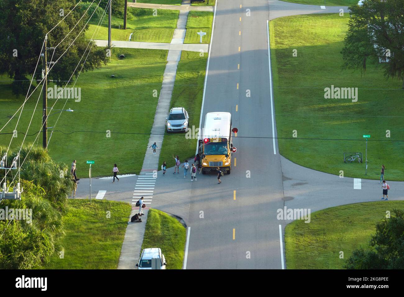 Top view of standard american yellow school bus picking up kids at ...