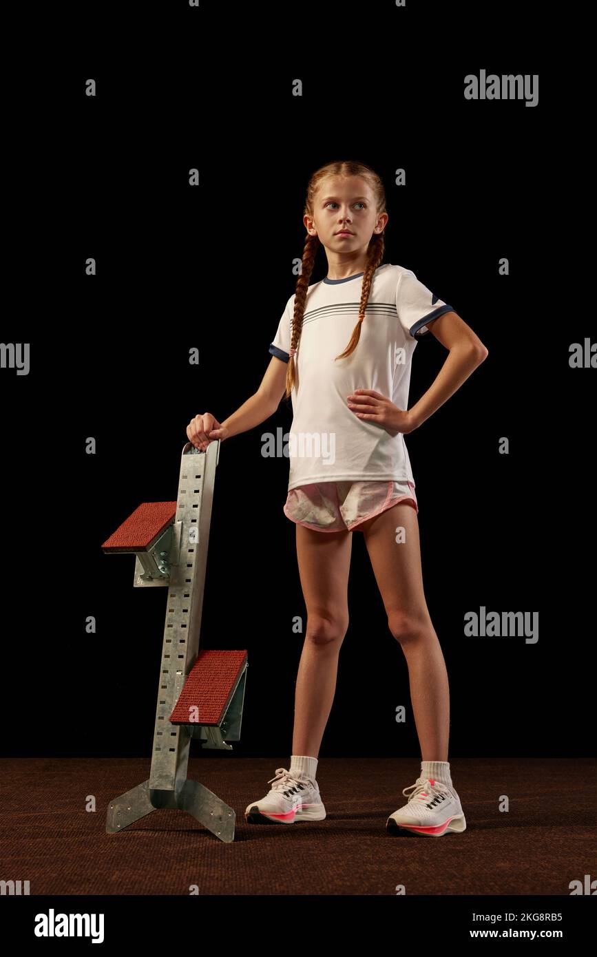 Portrait of little girl, beginner athlete in sportswear posing with ...