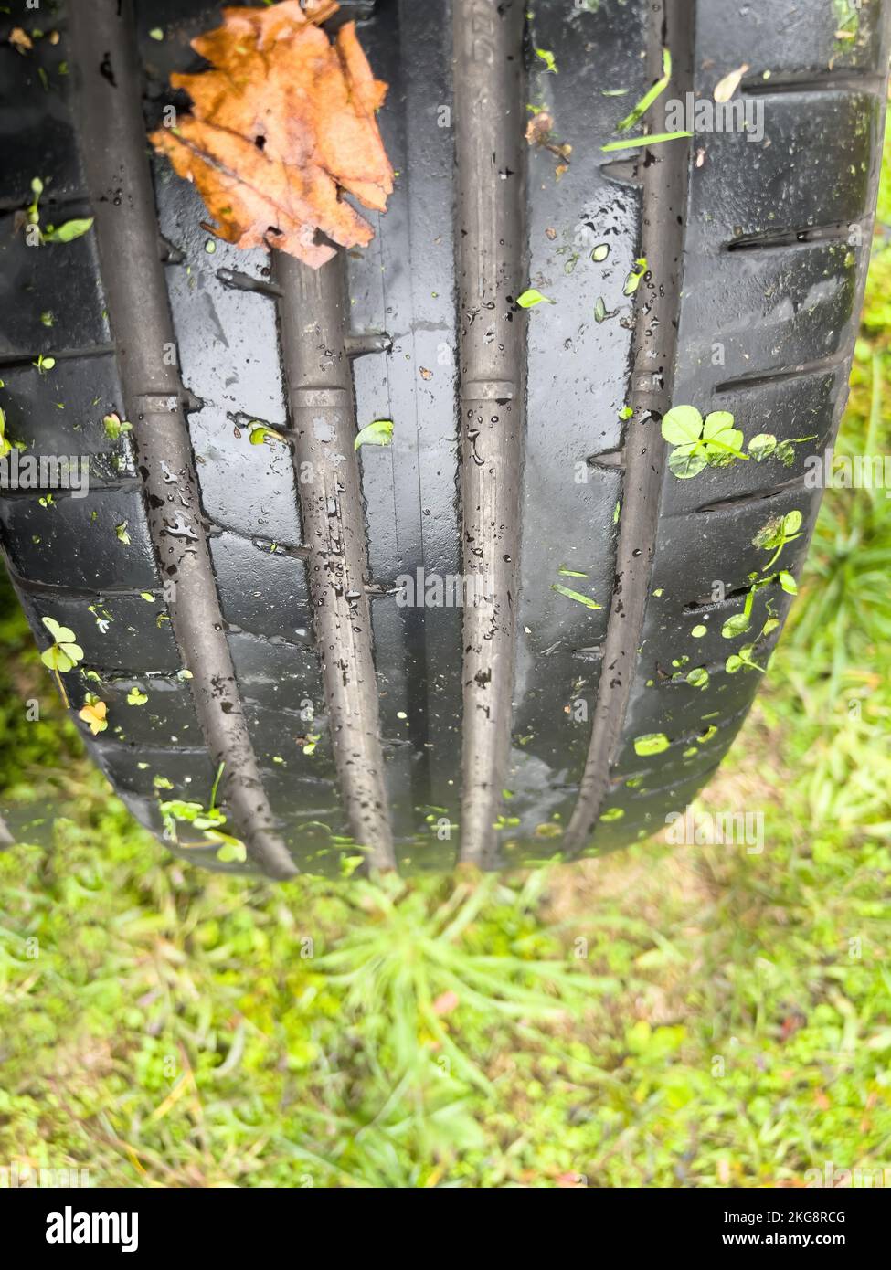 View from above of used car tyre - green grass background - dangerous ...