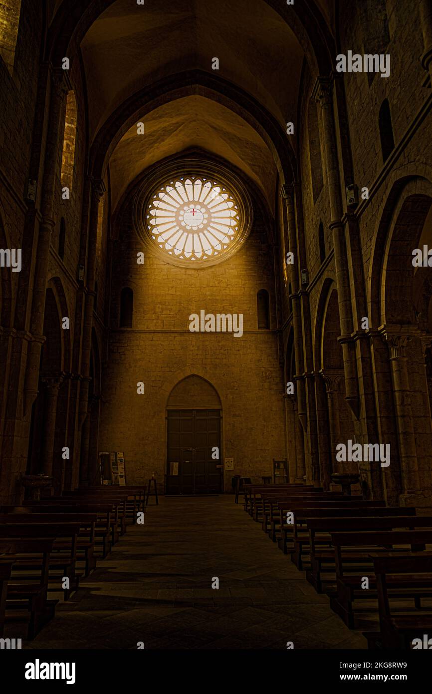A vertical image inside the gothic church Fossanova Abbey, light coming from a rose window Stock ...