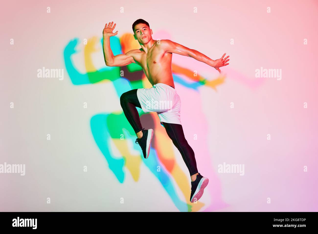 Portrait of young muscular man training, running isolated over pink ...