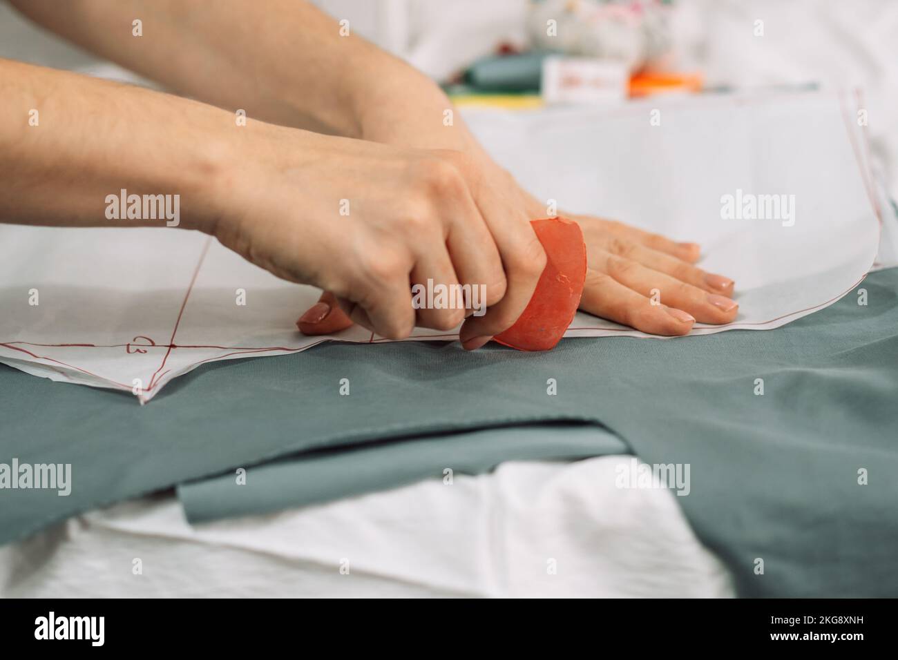 Lady draws patterns on the fabric with chalk Stock Photo - Alamy