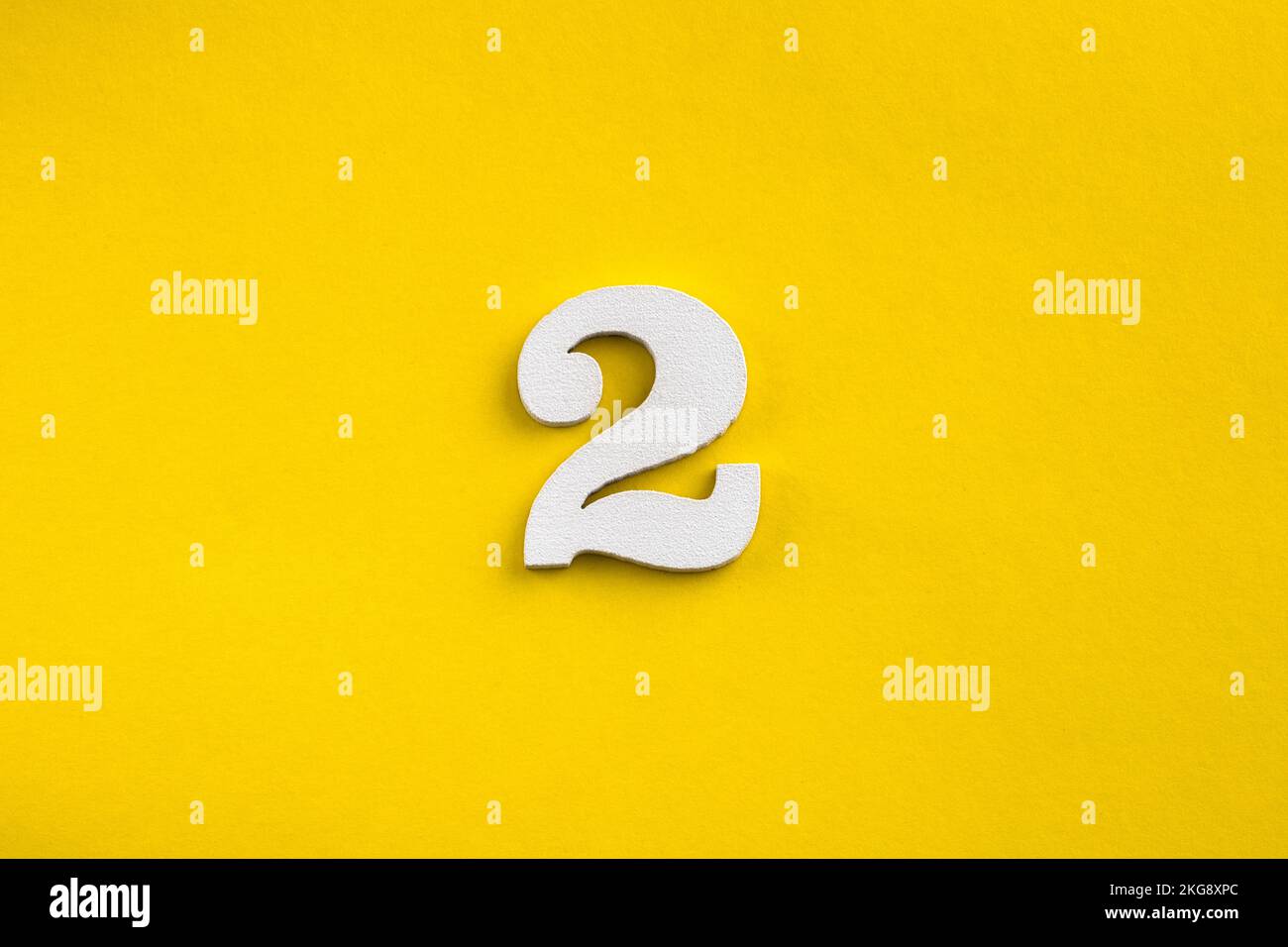 number two - white number in wood on yellow background Stock Photo - Alamy