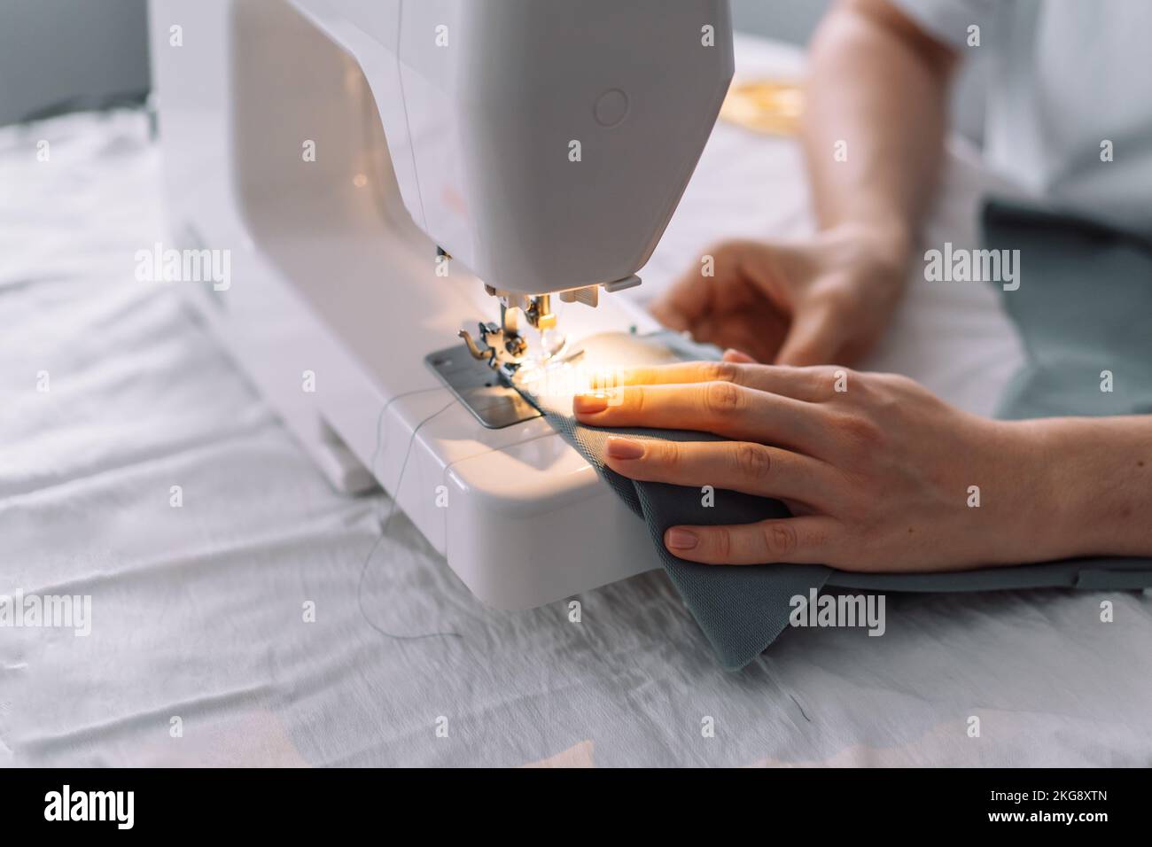 Lady stitching the edges of the fabric of a sewing machine Stock Photo ...