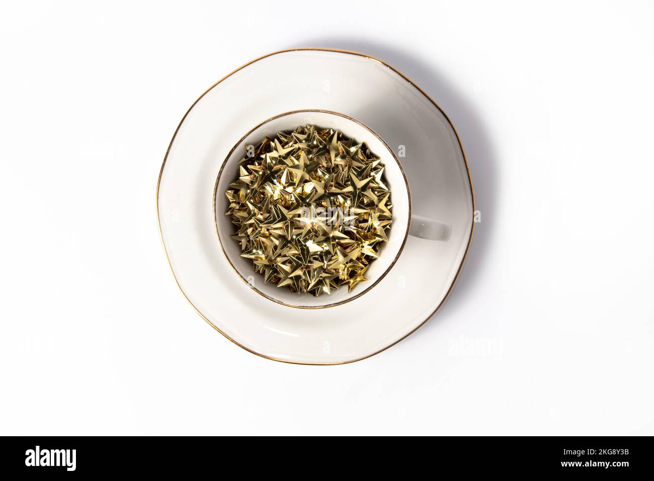 Tea cups filled with gold stars on white background Stock Photo - Alamy