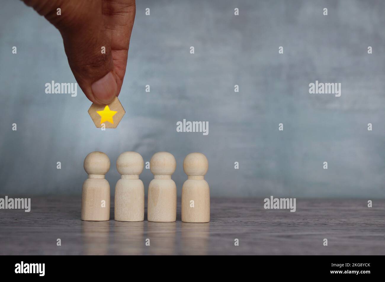 Hand holding a star over the team. Awarding, appreciation and reward ...