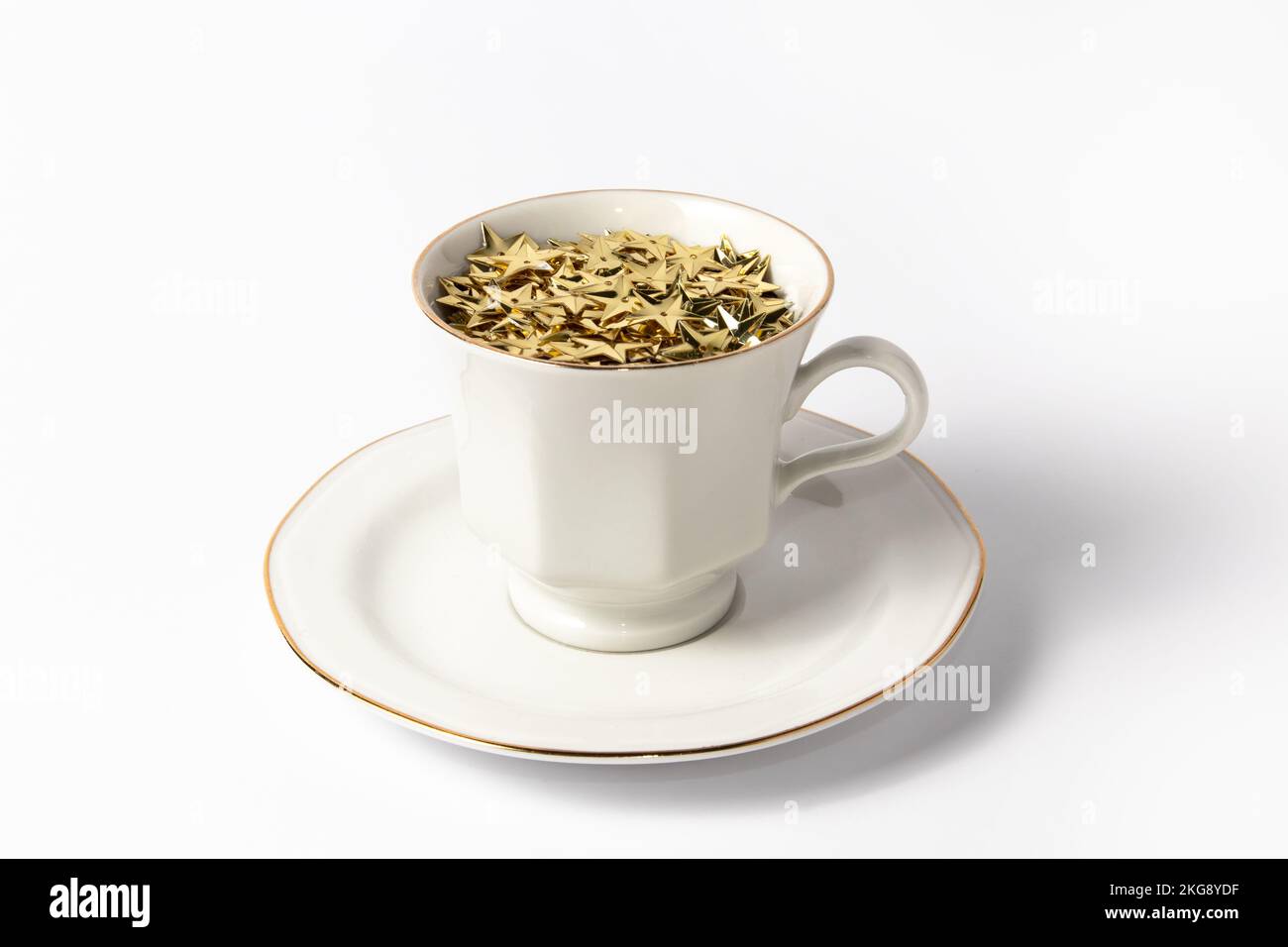 Tea cups filled with gold stars on white background Stock Photo - Alamy