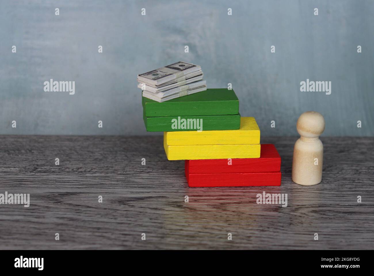 Wooden doll and stack of money on top of staircase. Reward, bonus ...