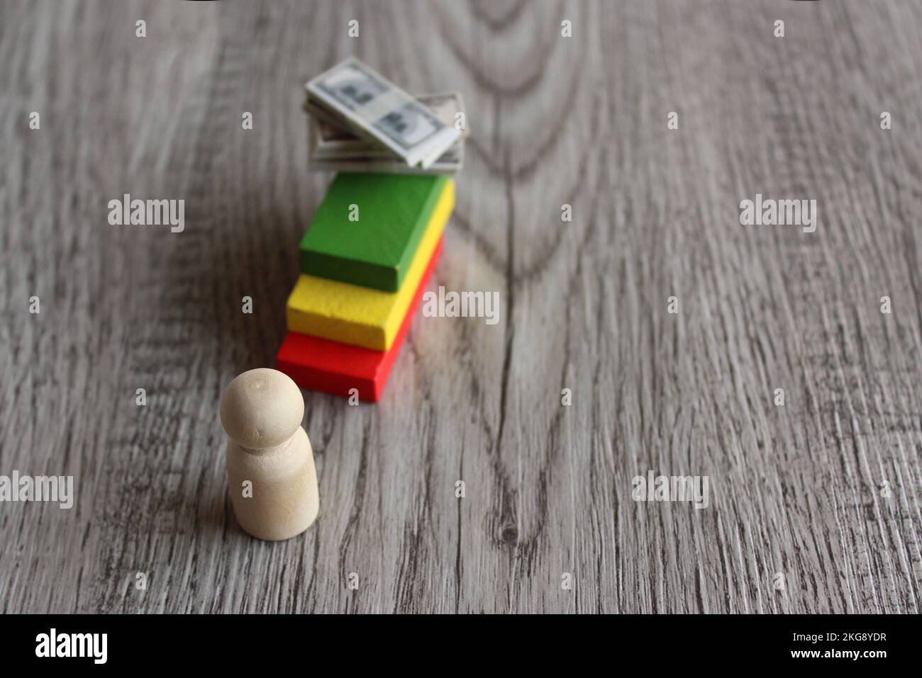 Wooden doll and stack of money on top of staircase. Reward, bonus ...