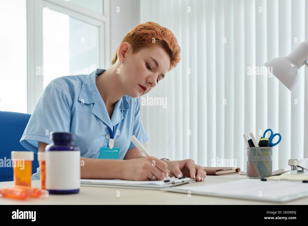 Young female general practitioner writing out prescription Stock Photo ...