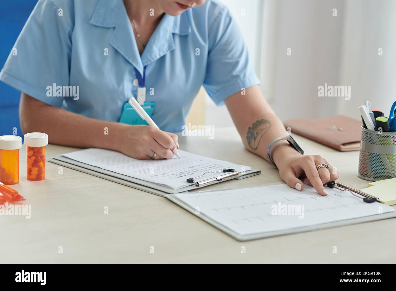 Cardiologist describing cardiogram of patient and taking notes in ...