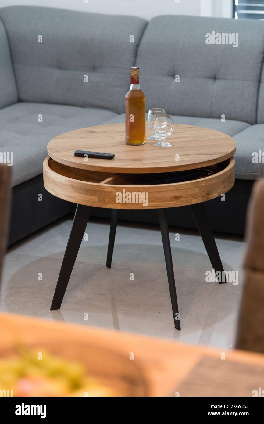 Round table with bottle and 2 glasses in living room of modern ...