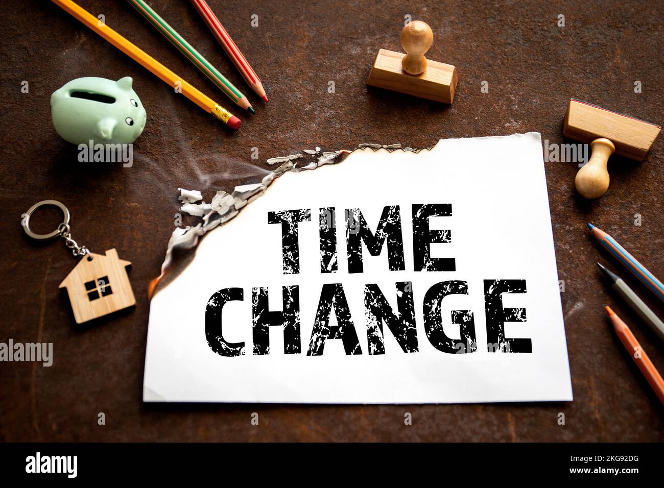 TIME CHANGE. Burning sheet of paper and office supplies on rusty metal ...