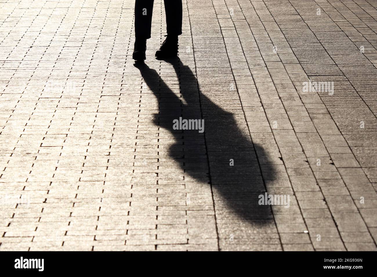Black silhouette and long shadow of lonely slim girl walking on a ...