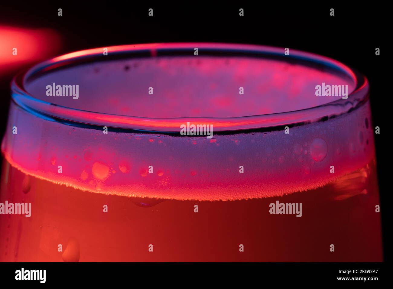 A horizontal image of the top of a full glass of Champaign in the dark ...