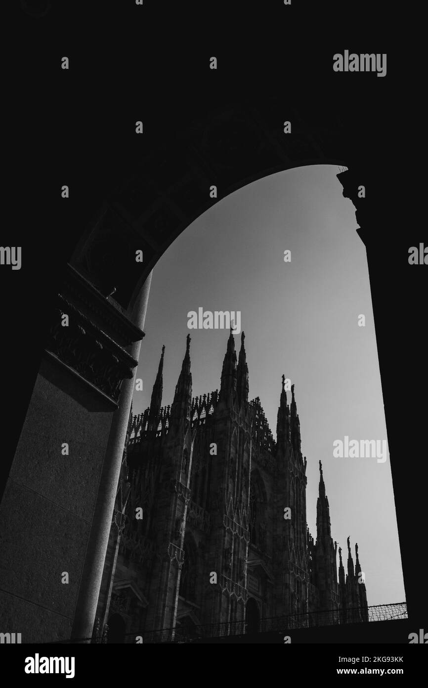A vertical grayscale low-angle shot of the Cologne Cathedral in Germany ...