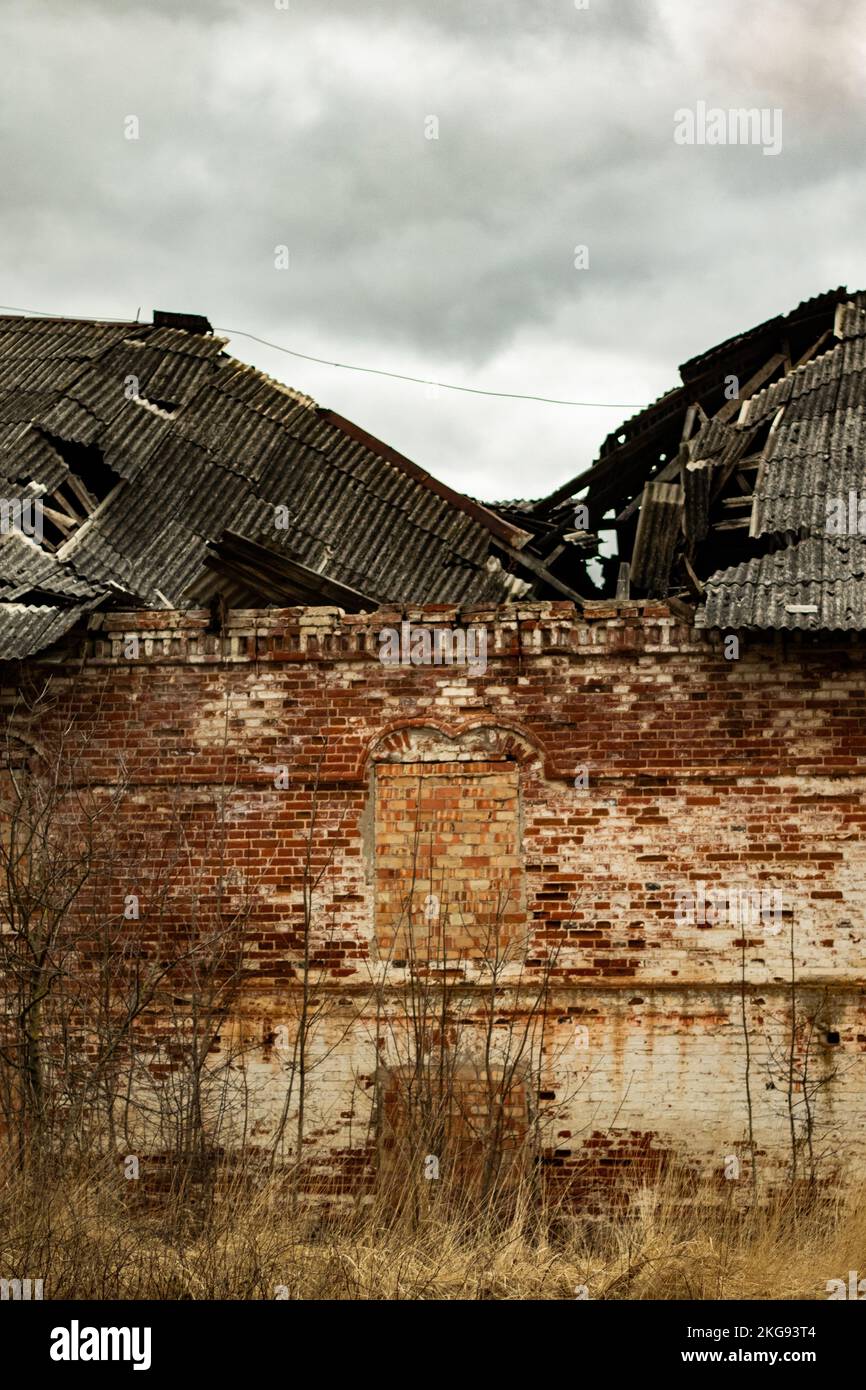 A vertical low angle shot of an old abandoned brick building with a ...
