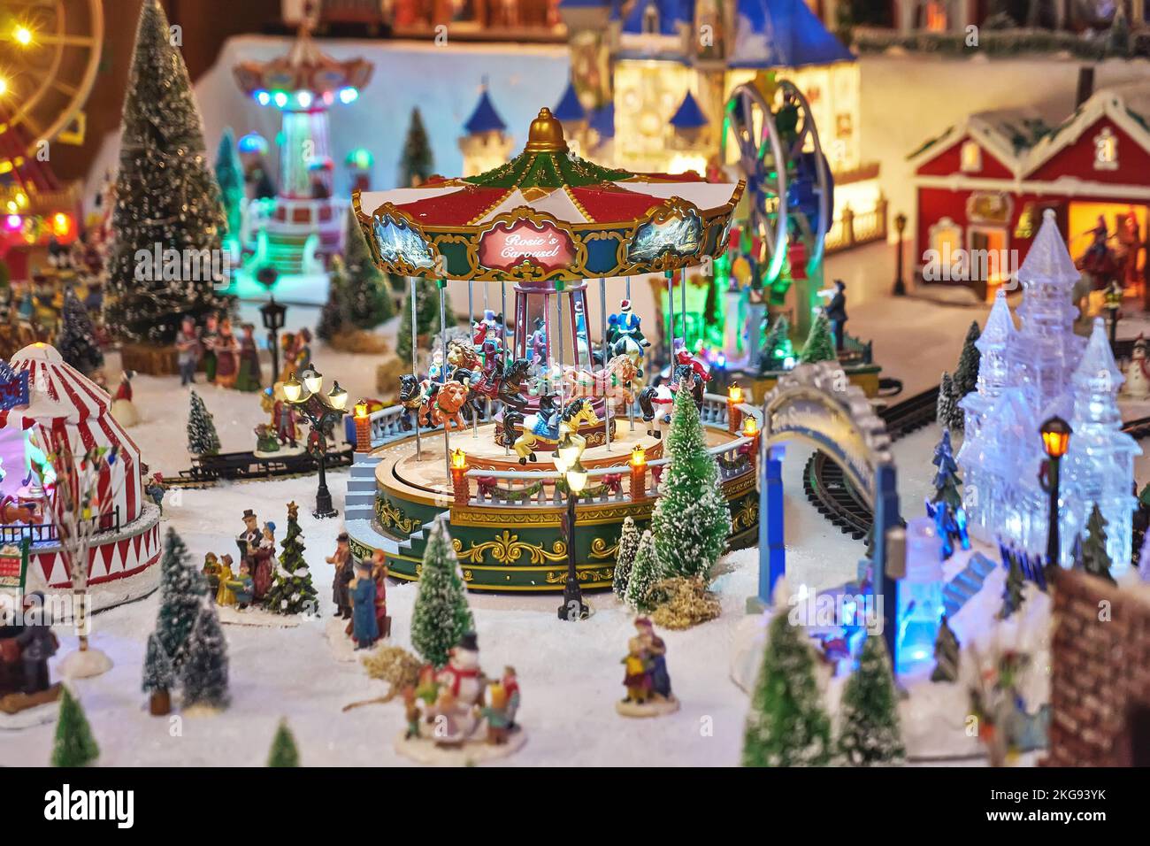 Cheerful miniature carousel with toy people in winter park during ...