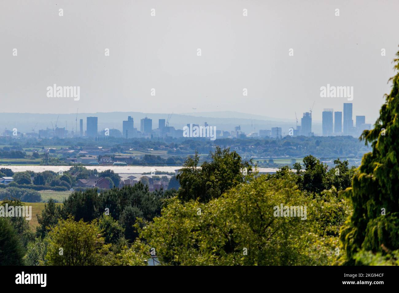 A landscape of a beautiful green meadow on the background of a city ...