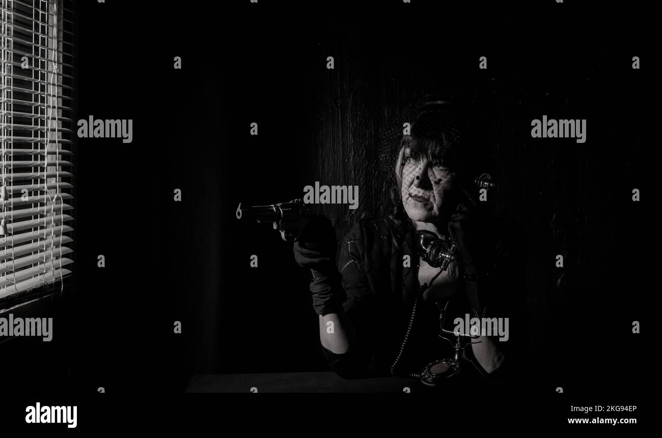 A monochrome shot of an elderly woman in a black veil talking on the ...