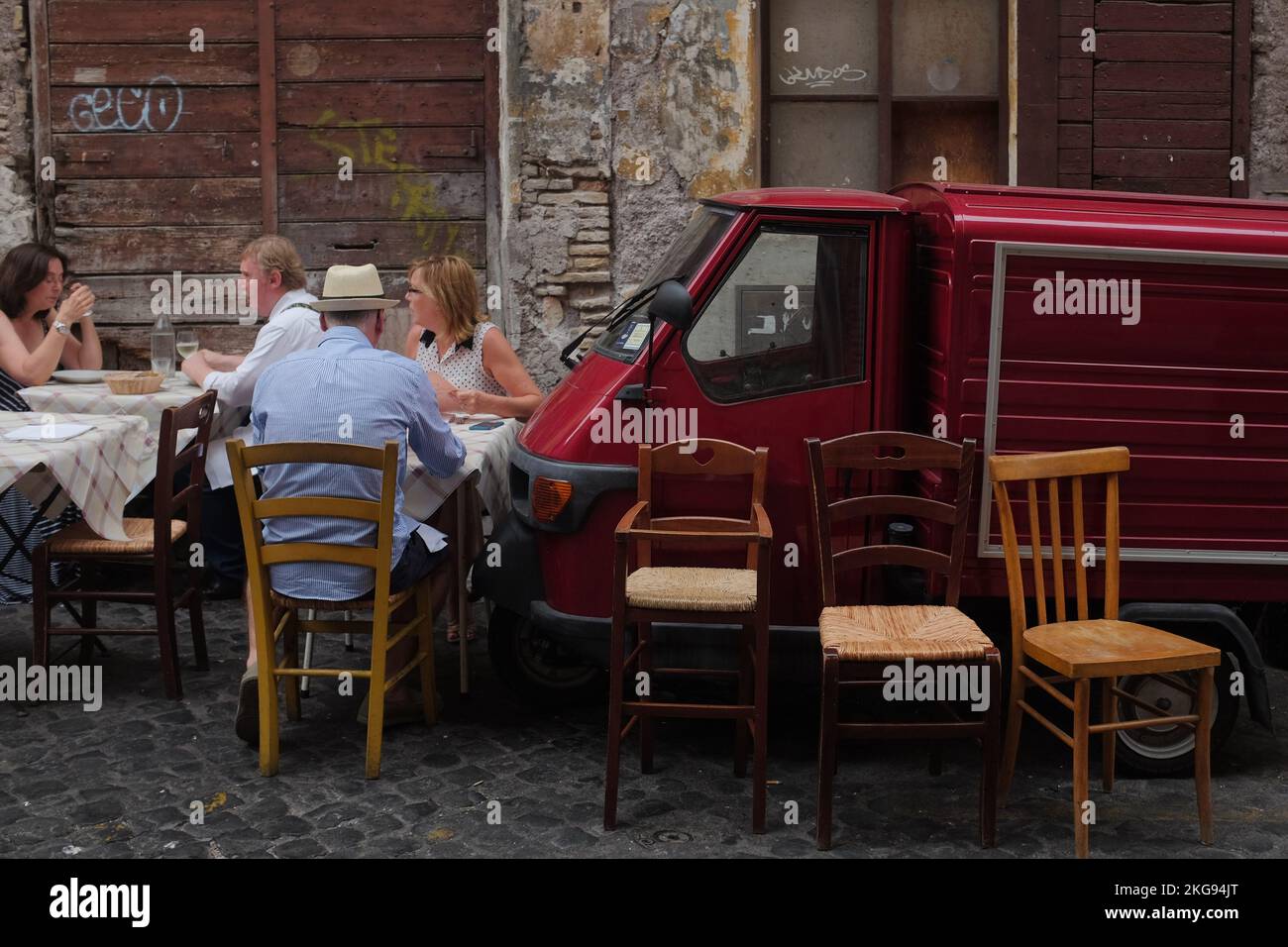 Rome, Italy: couples dine outdoors at small tables along a cobblestone ...