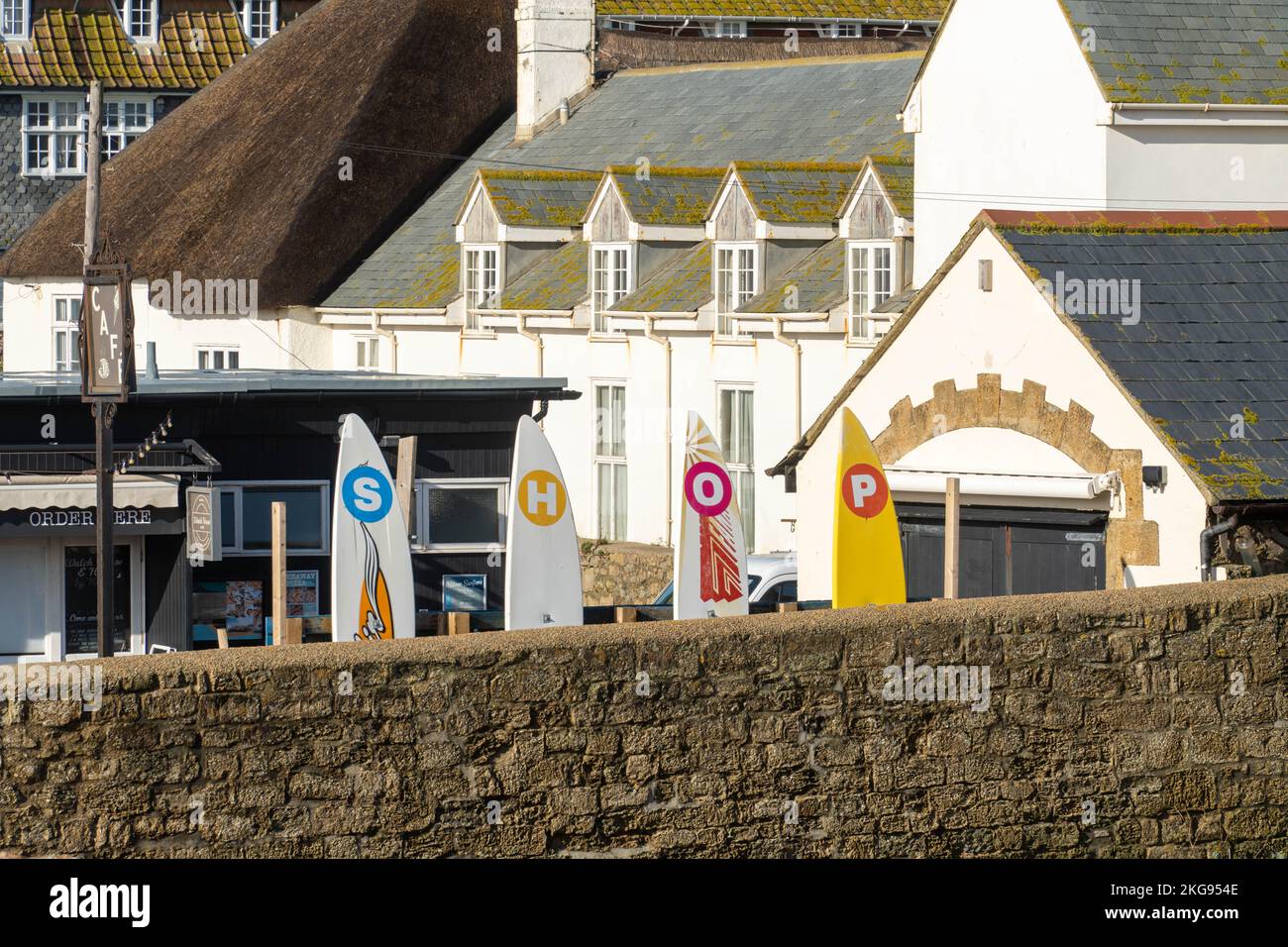 Four, lettered, upright surfboards spell out the word 'shop' near the ...