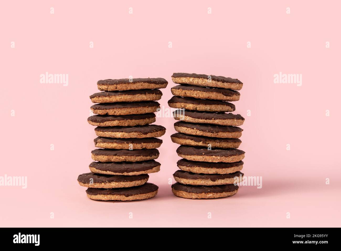 Stacks of chocolate-covered cookies on pink background Stock Photo - Alamy