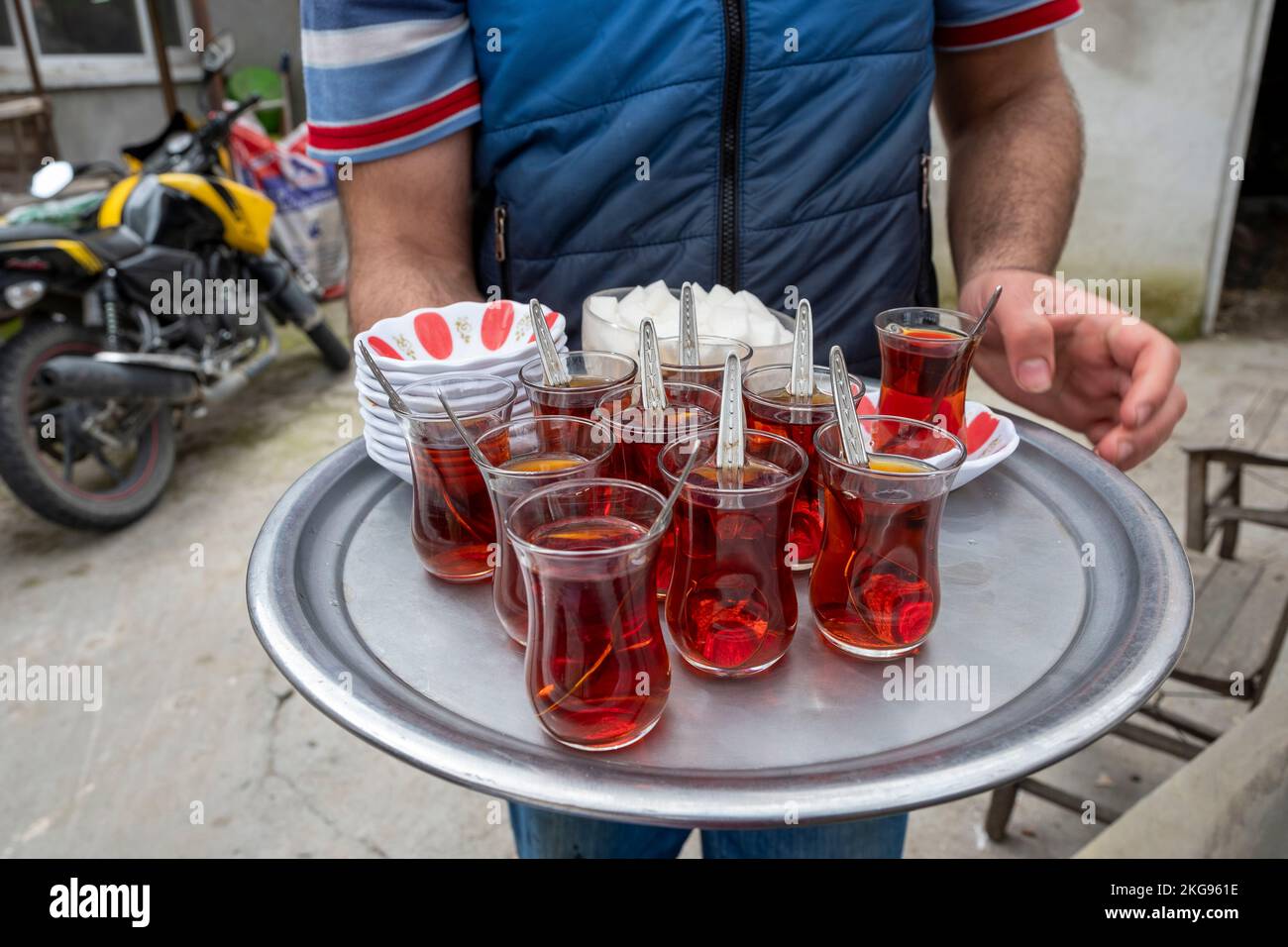 A man serving traditional turkish tea in glasses, on a metal tray, in ...