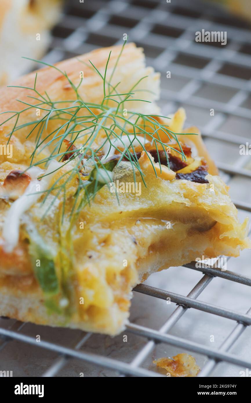 A vertical closeup shot of a delicious pizza with cheese and greens ...