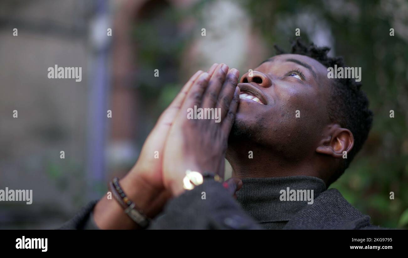 Religious young black man praying to God. African person looking up at ...