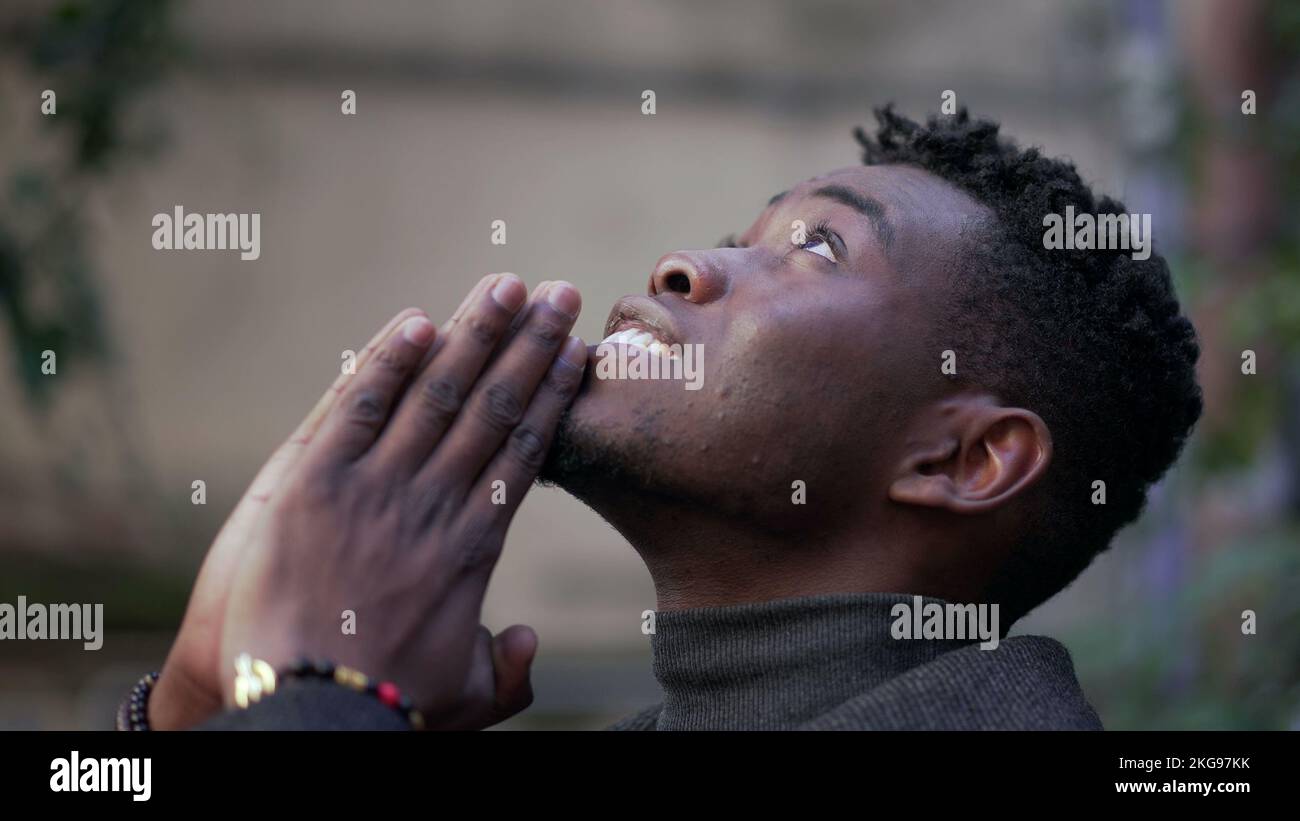 Spiritual young black African man praying to God Stock Photo - Alamy