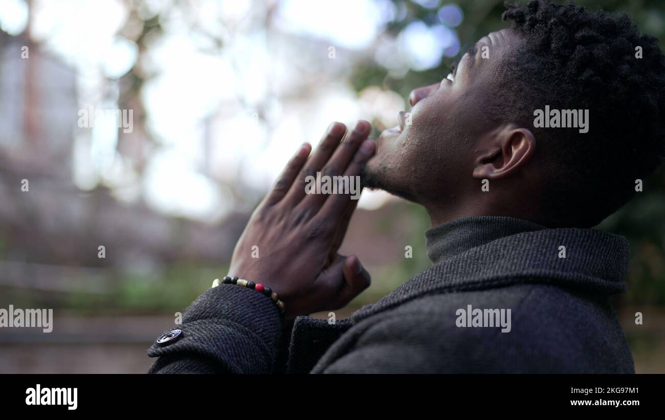 Spiritual young black African man praying to God Stock Photo - Alamy