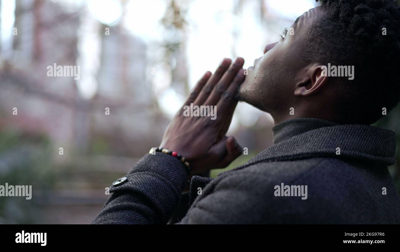 Spiritual young black African man praying to God Stock Photo - Alamy