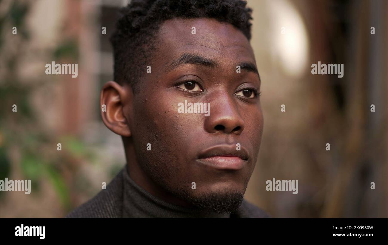 Serious young black man standing outdoors. Stoic handsome African ...