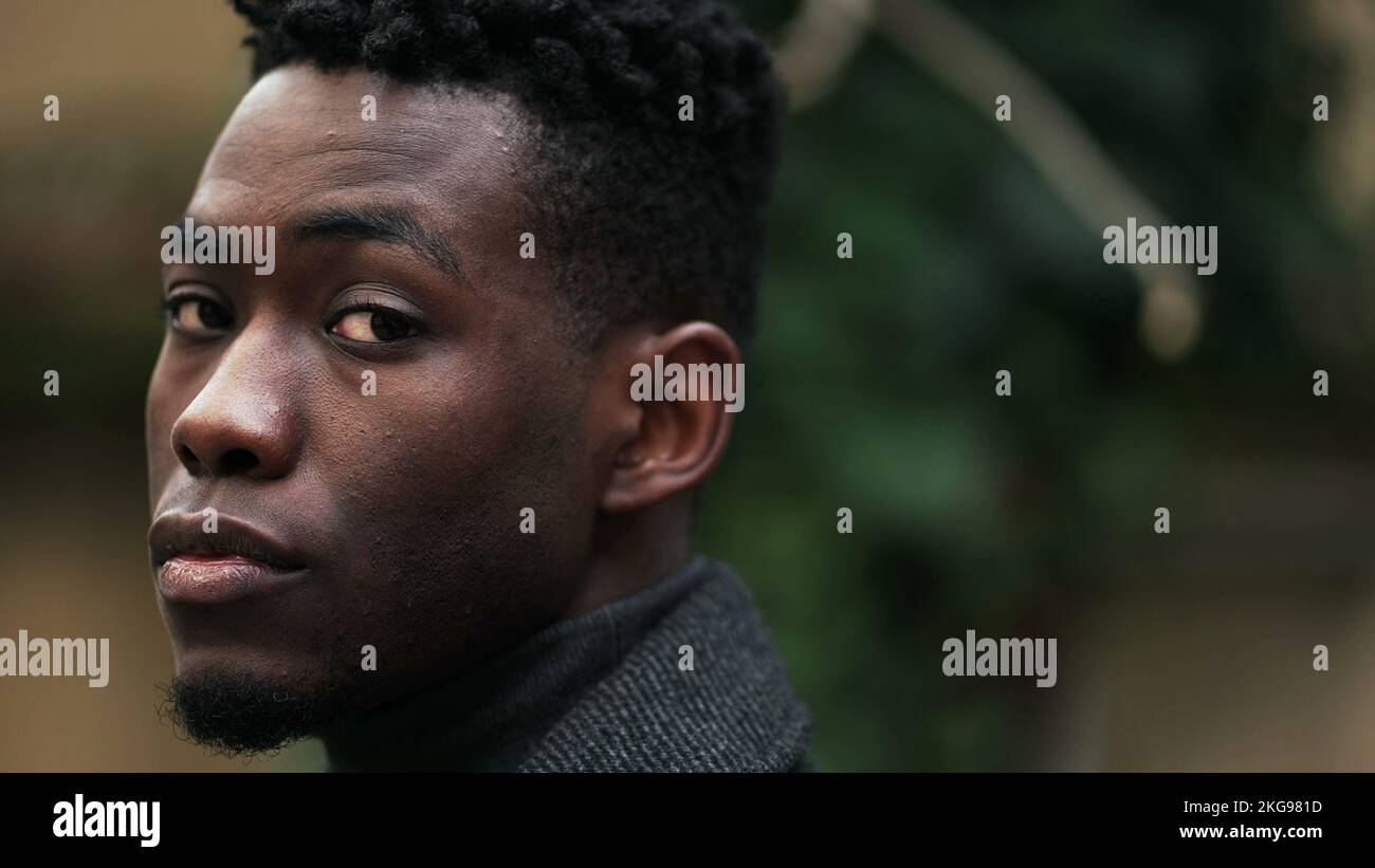 Serious young black African man no emotion expression staring camera ...