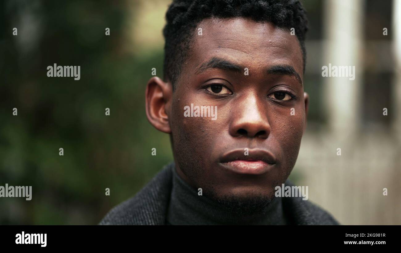 Serious young black African man no emotion expression staring camera, tracking face shot Stock ...
