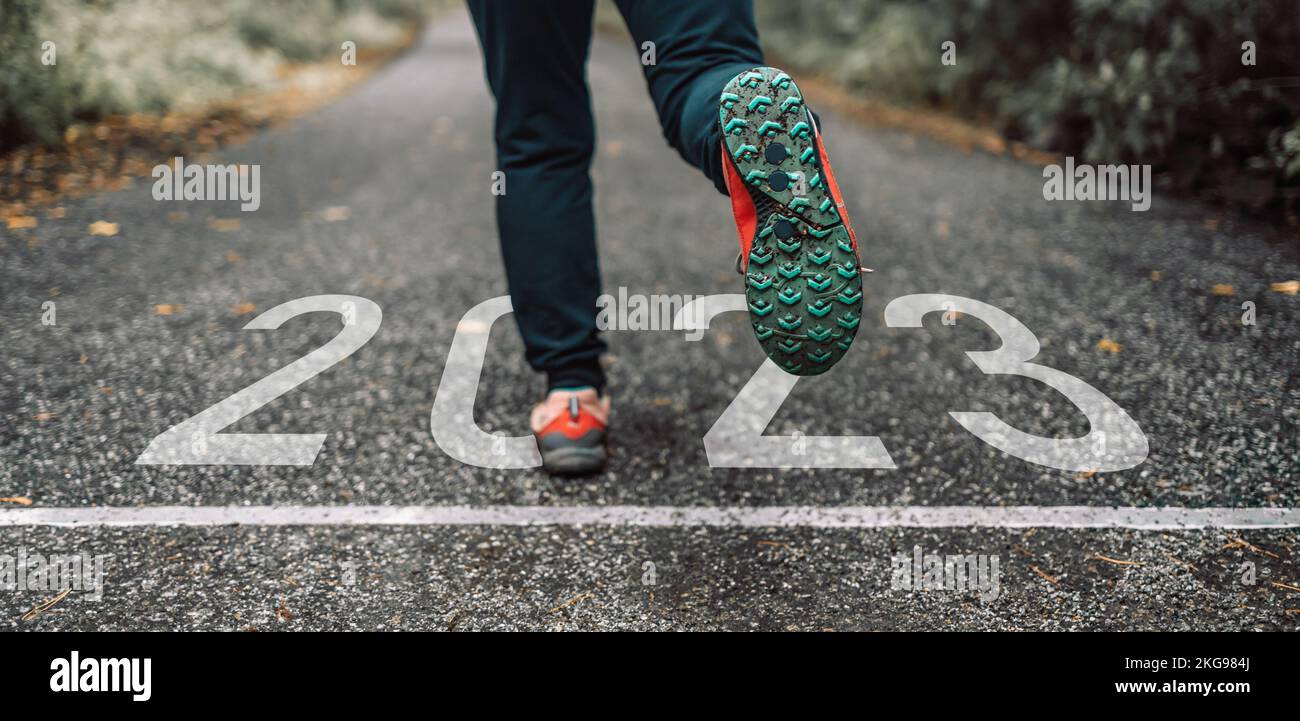 Numbers 2023 written on the asphalt road and female runners are ...