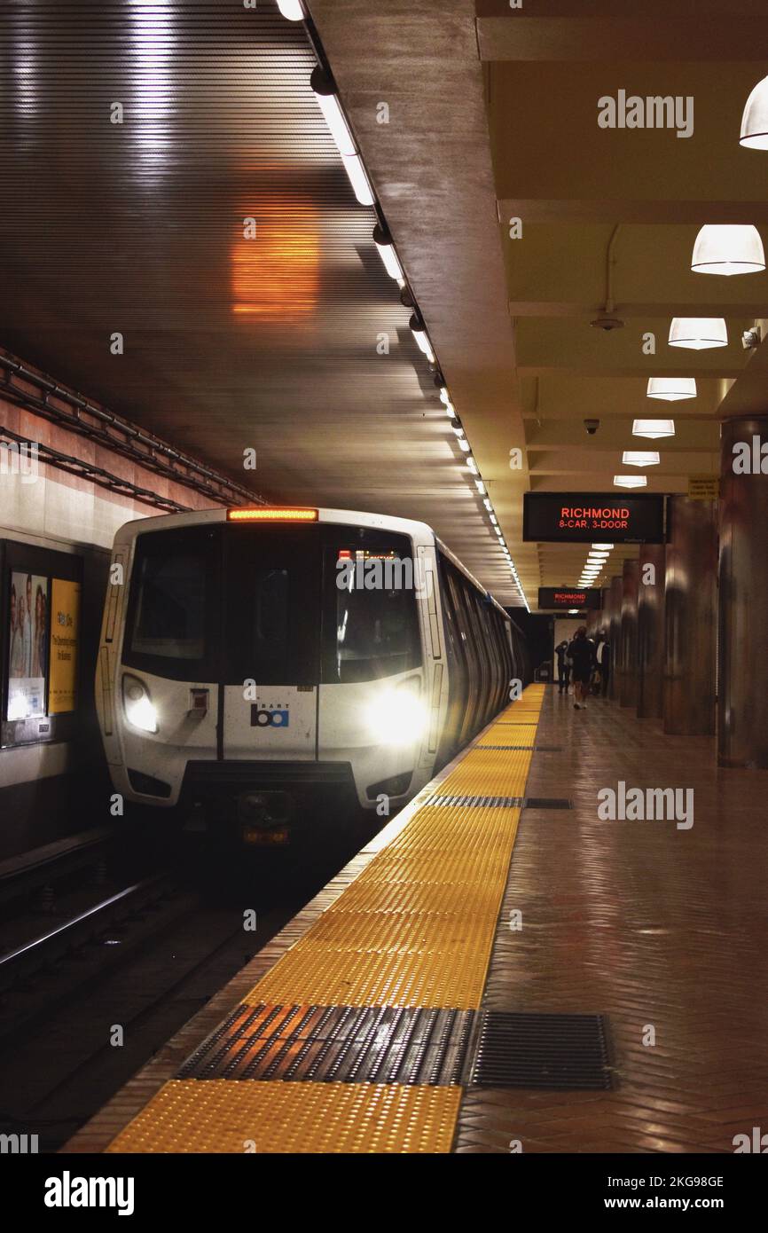 A vertical image of a train pulling in to the Powell St. BART Station ...