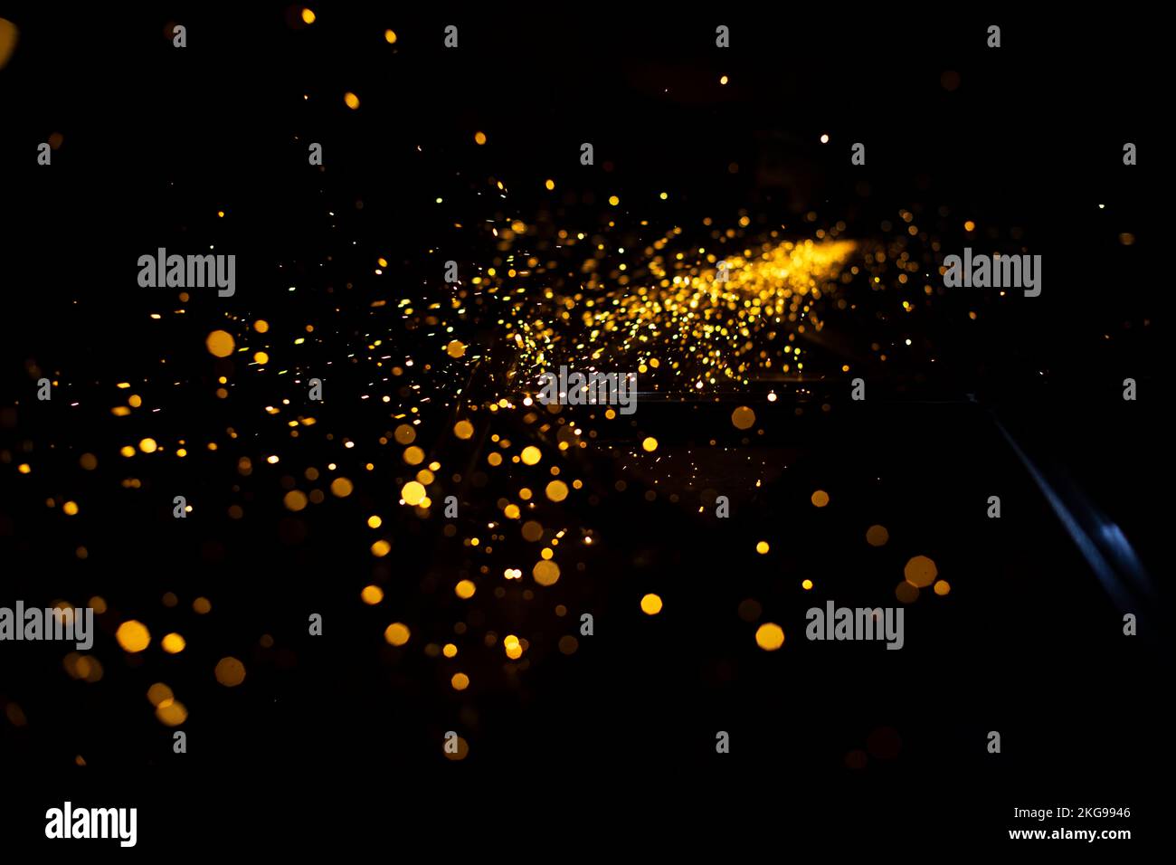 Sparks of yellow color. Metal treatment. Lights in dark. Sparks from ...