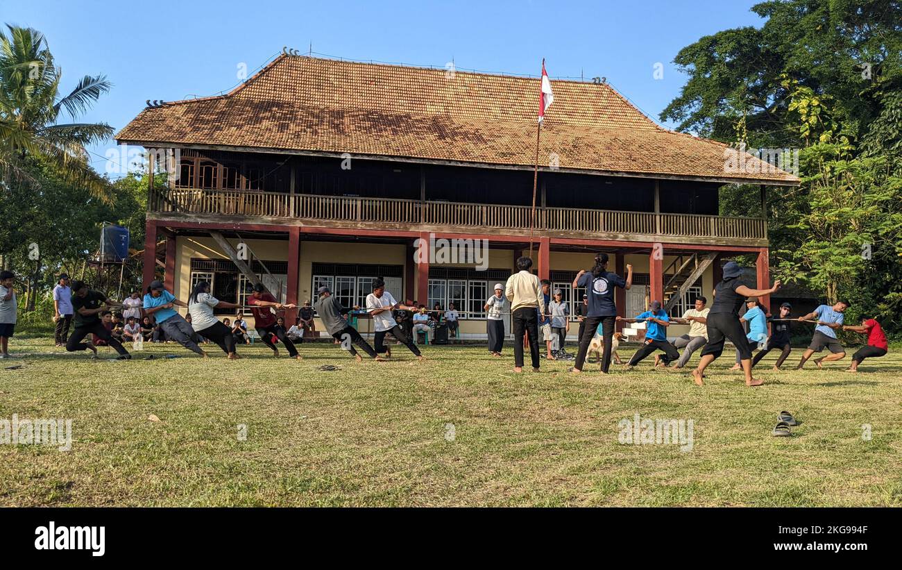 Two teams pulling on opposite ends of a rope during tug of war ...