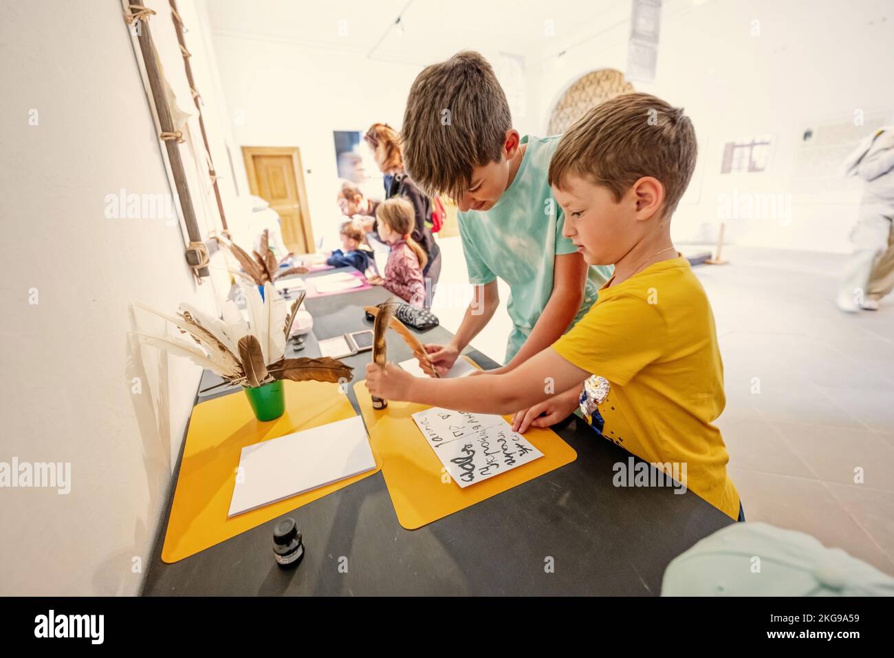 Boys writing with feather quill pen at desk Stock Photo - Alamy