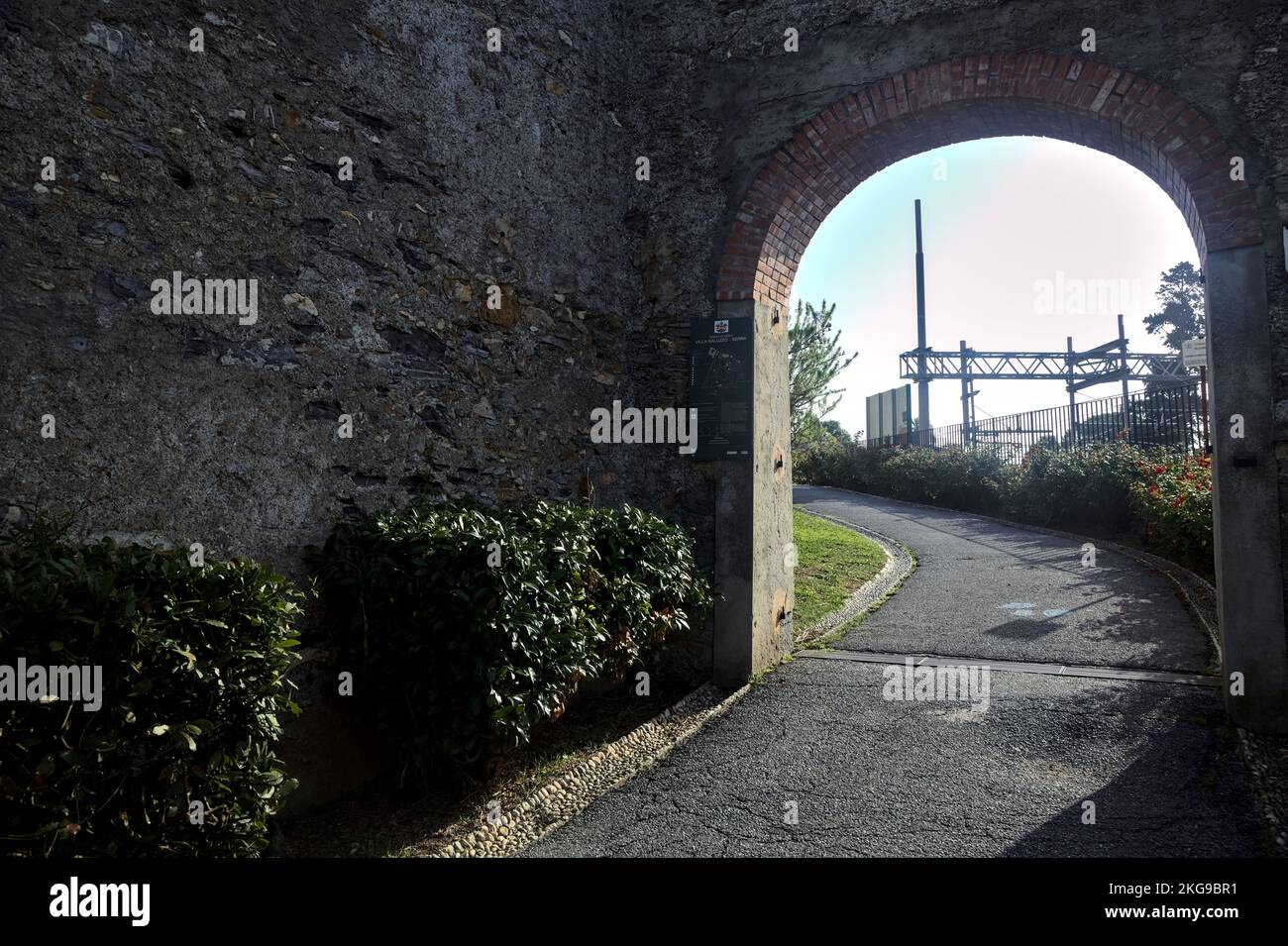 Path going through an arch of an ancient bounday wall in a park Stock ...