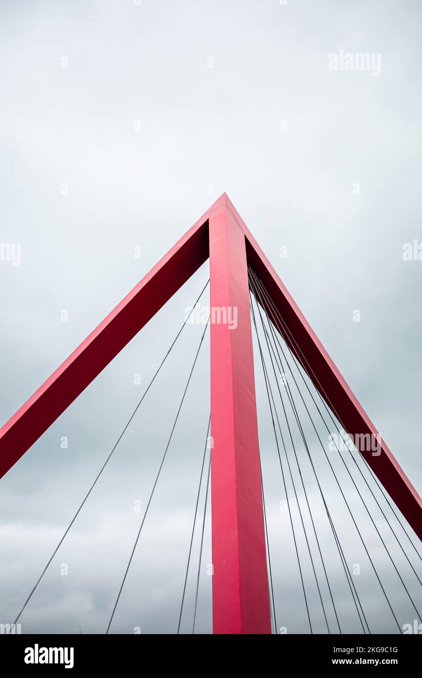 A low angle shot of a pyramid-shaped structure with wires and red ...